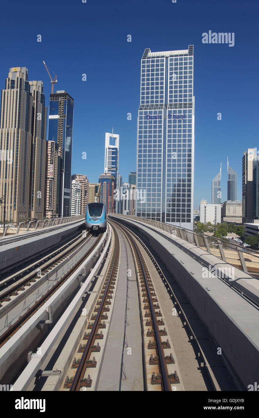 Dubai metro on Sheikh Zayed road with Emirates towers in background ...