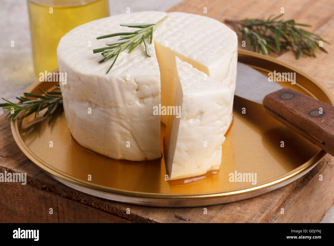 Wheel of brazilian traditional cheese Minas on wooden board with olive ...