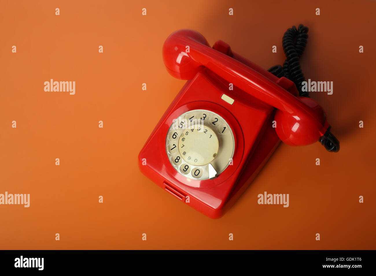 Beautiful red vintage phone on a orange background Stock Photo - Alamy