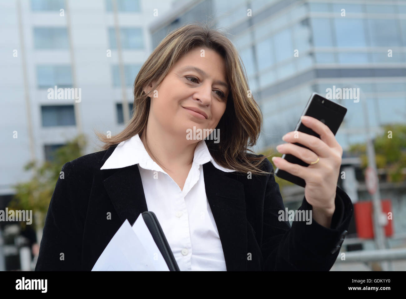 Portrait of beautiful business woman reading a message on her phone ...