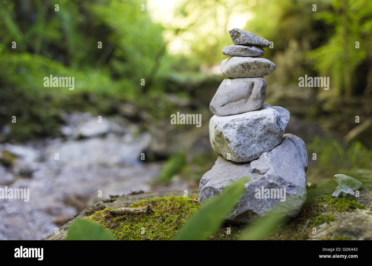 Stack of pebble stones by a stream in a forest Stock Photo - Alamy