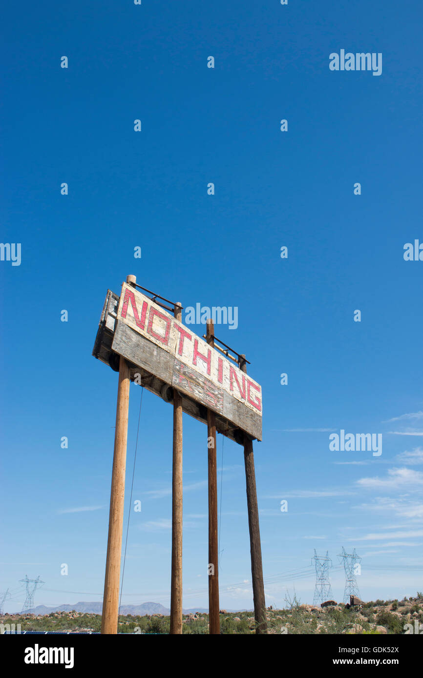 An old, weathered billboard sign with the word NOTHING against a clear ...