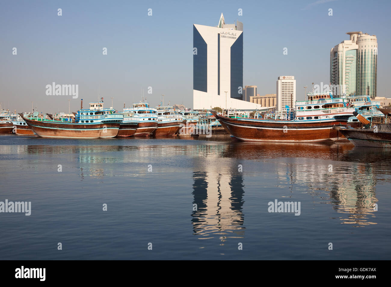 Traditional Dhow boats moored in Dubai Creek with modern buildings ...