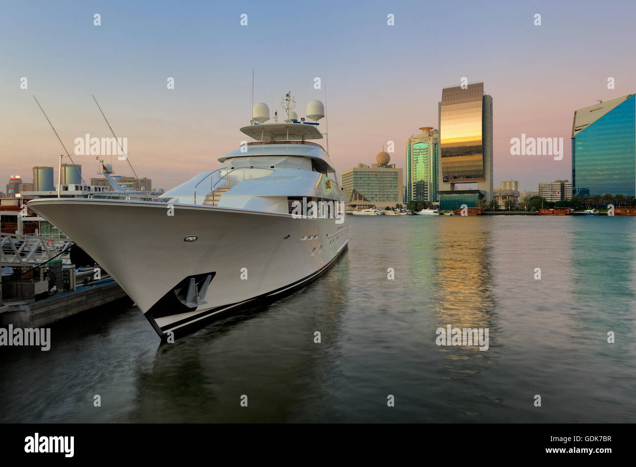 Modern boat moored on Dubai Creek with National Bank of Dubai building ...