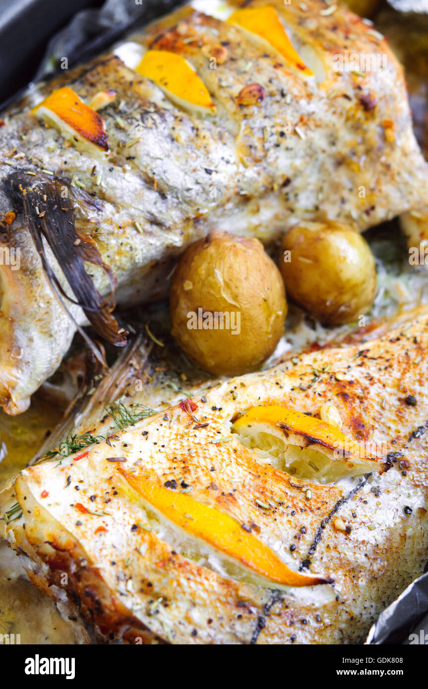 Baked haddock with lemon slices and small potatoes Stock Photo - Alamy