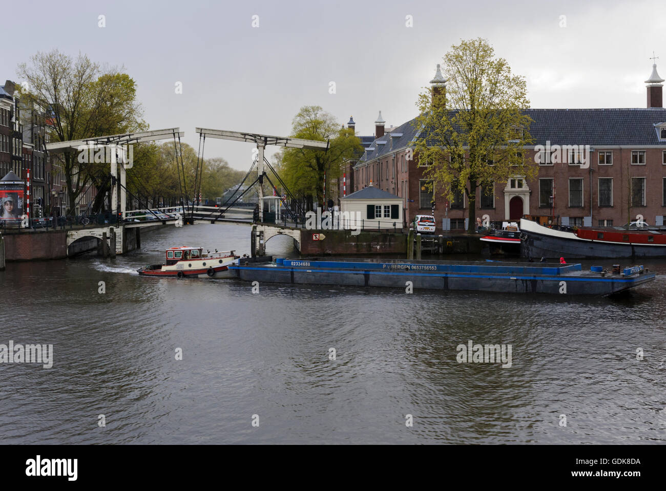 A boat passing a traditional wooden bridge in Amsterdam, Holland ...