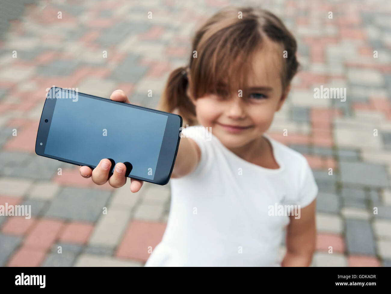 Adorable little girl with a smartphone outdoors Stock Photo - Alamy