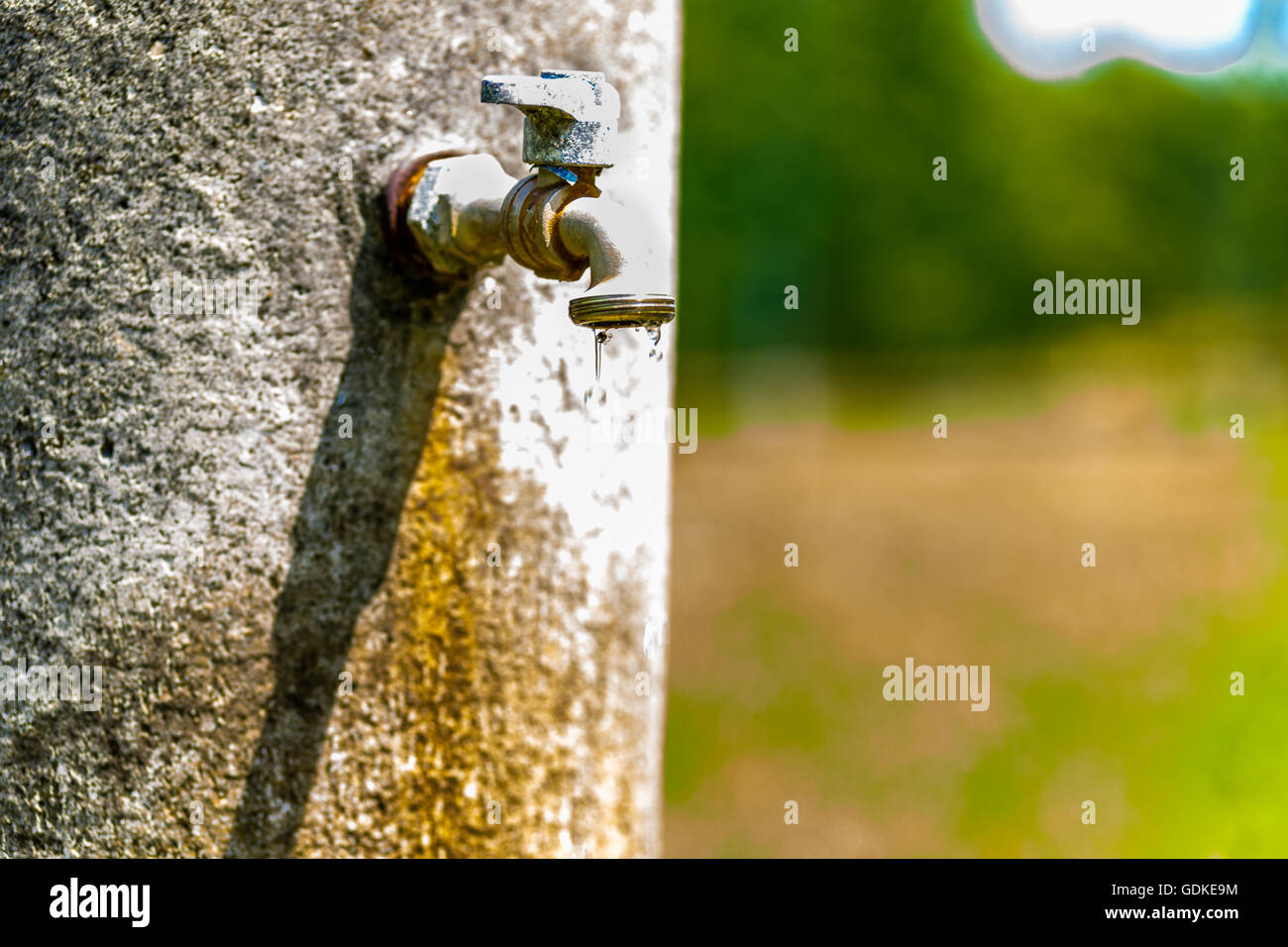 old rusty faucet leaves drawing a small stream of water Stock Photo - Alamy