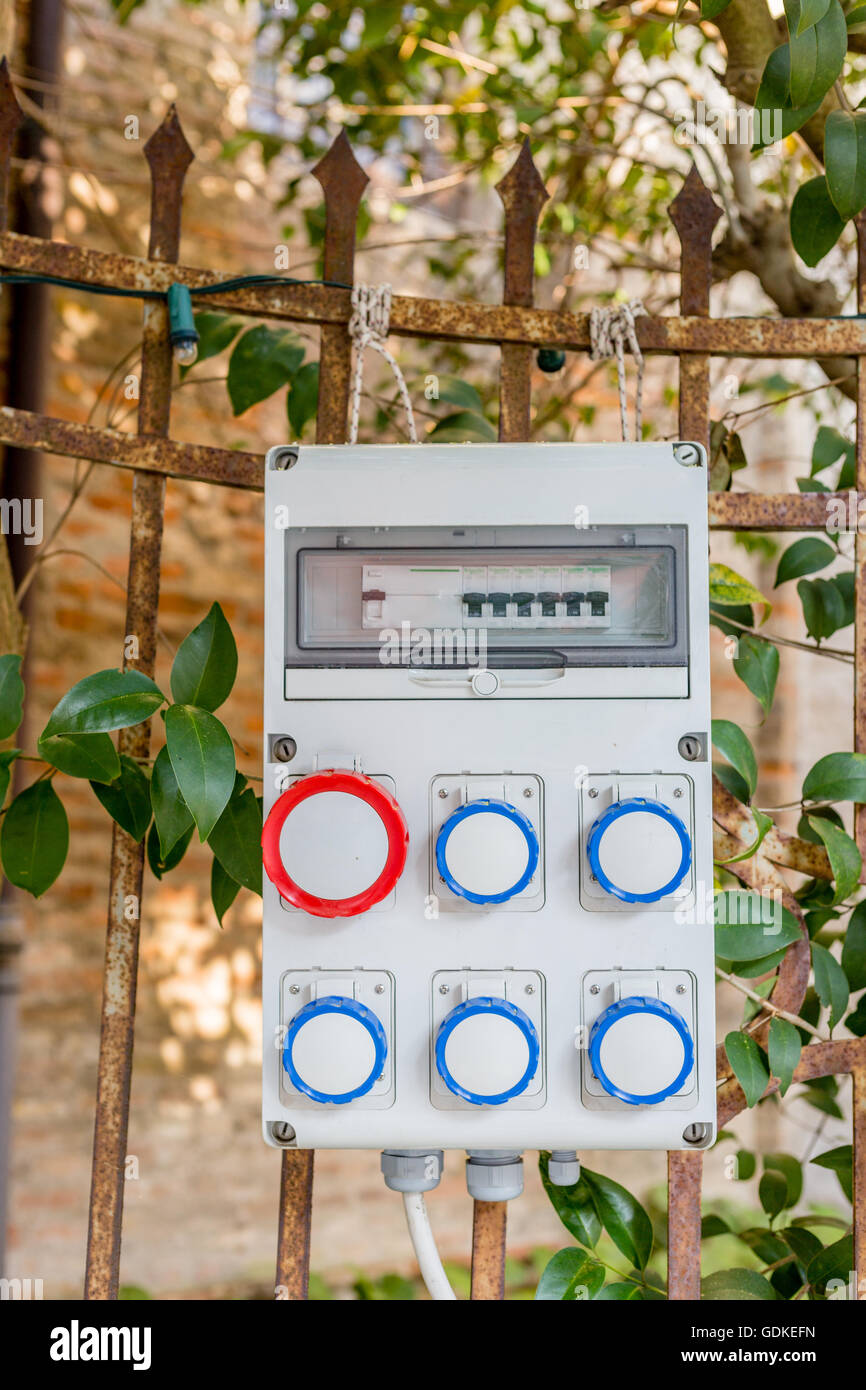 electrical panel hung on the grate of a garden Stock Photo - Alamy