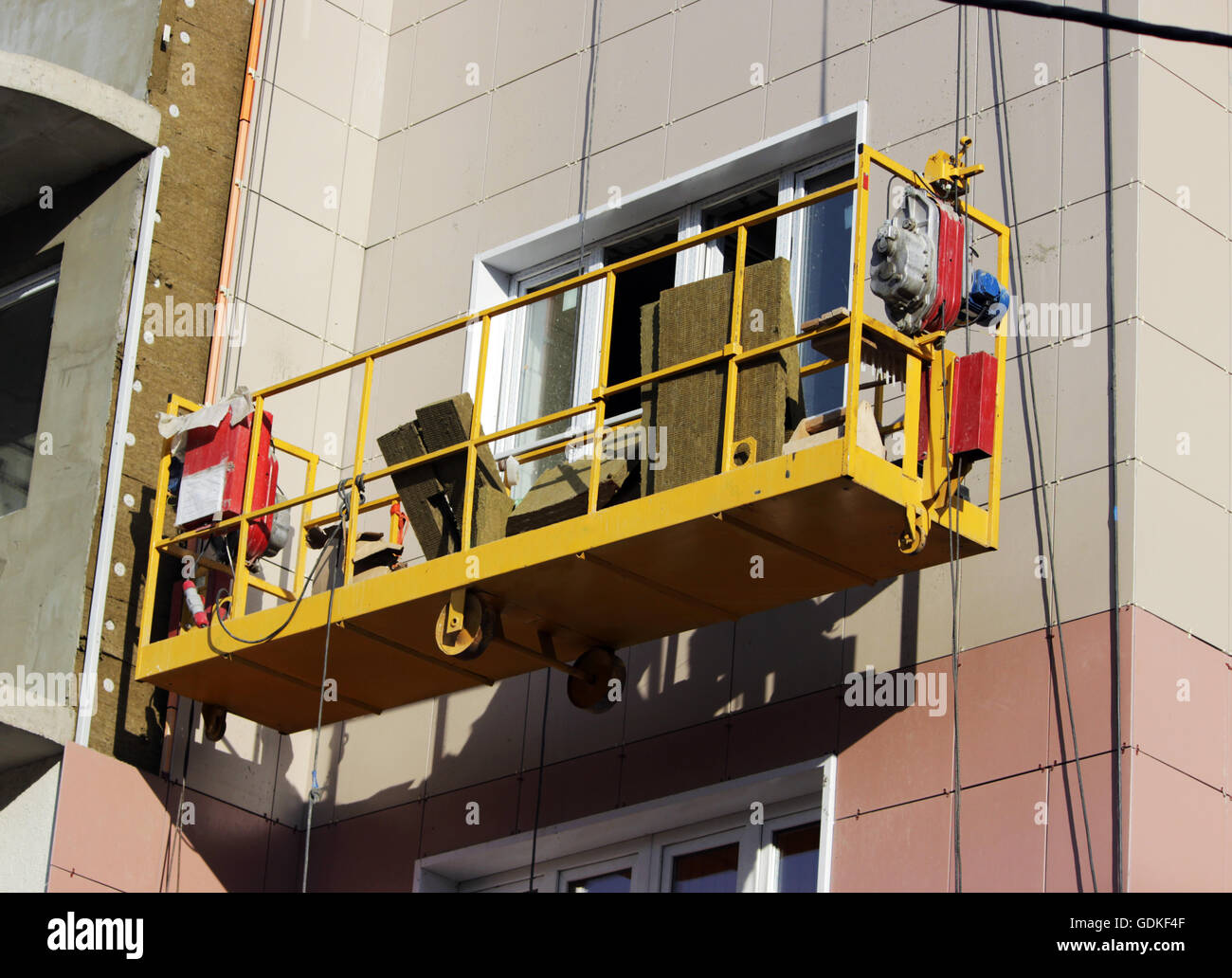construction suspended yellow cradle without workers on a newly built ...