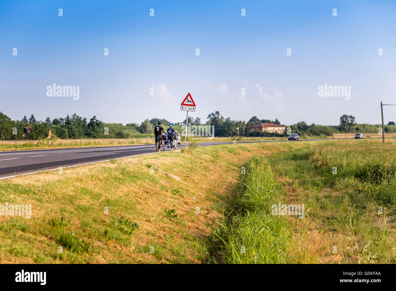 cyclists walking on a highway with the bicycle at their side Stock ...