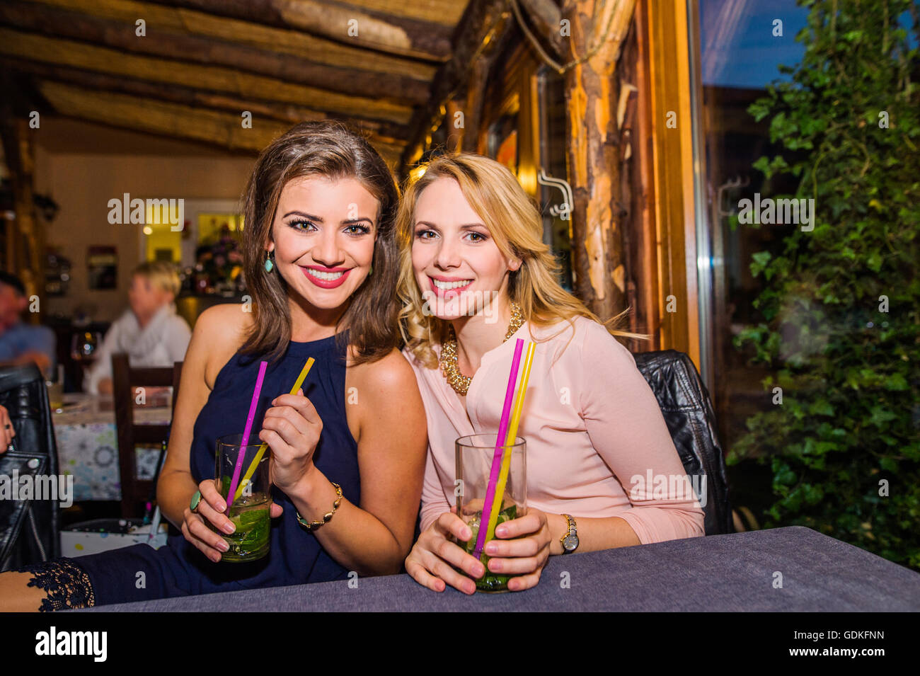 Young beautiful women with cocktails in bar or club Stock Photo - Alamy