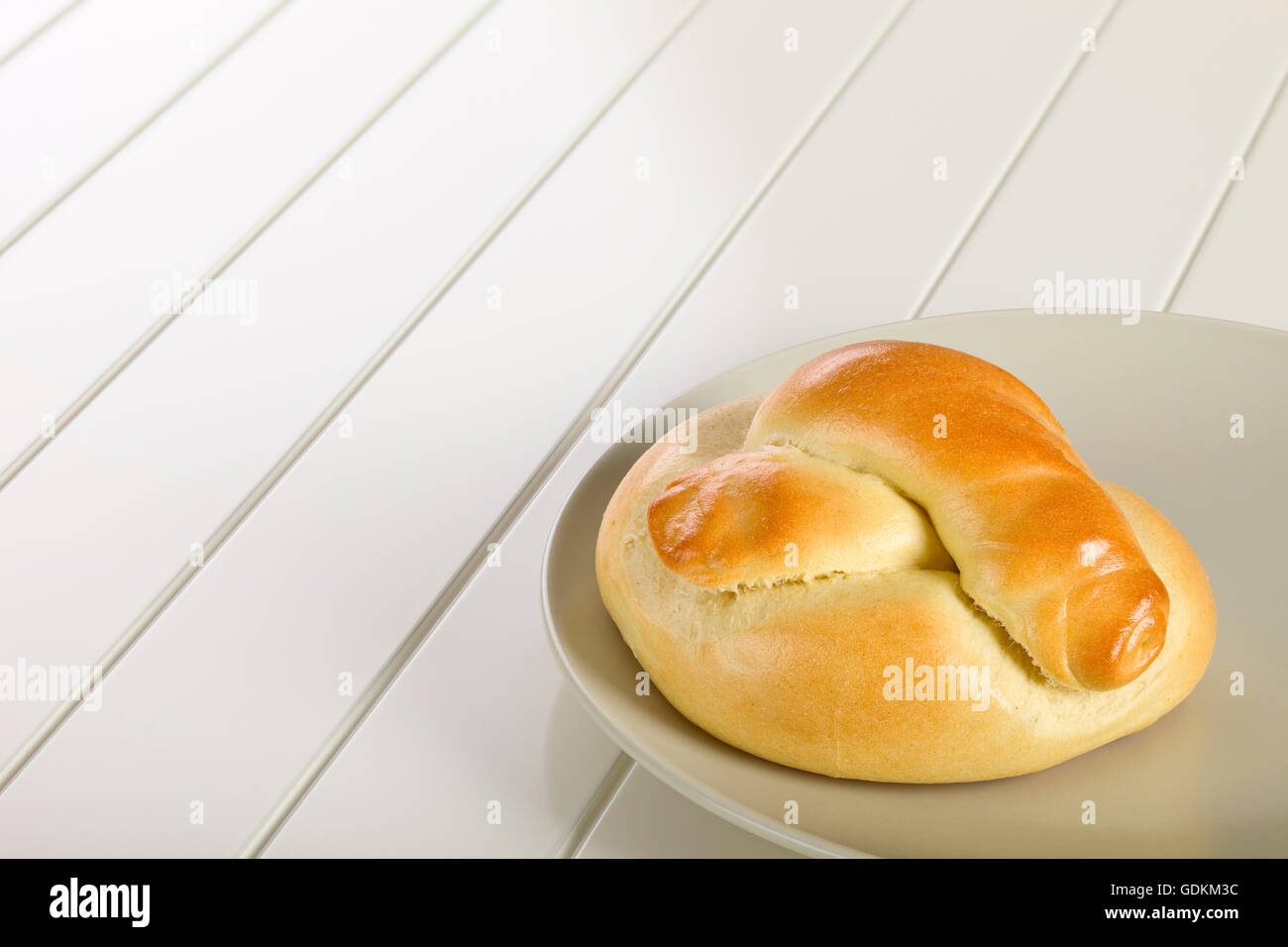 Bread roll on ceramic plate, white wooden background Stock Photo - Alamy