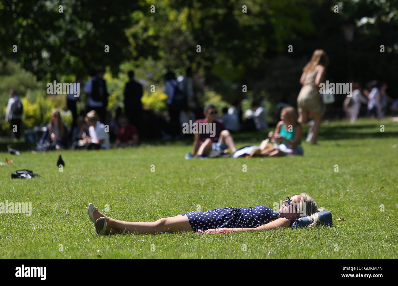 People enjoy the hot weather in St James's Park in London, as a mini ...