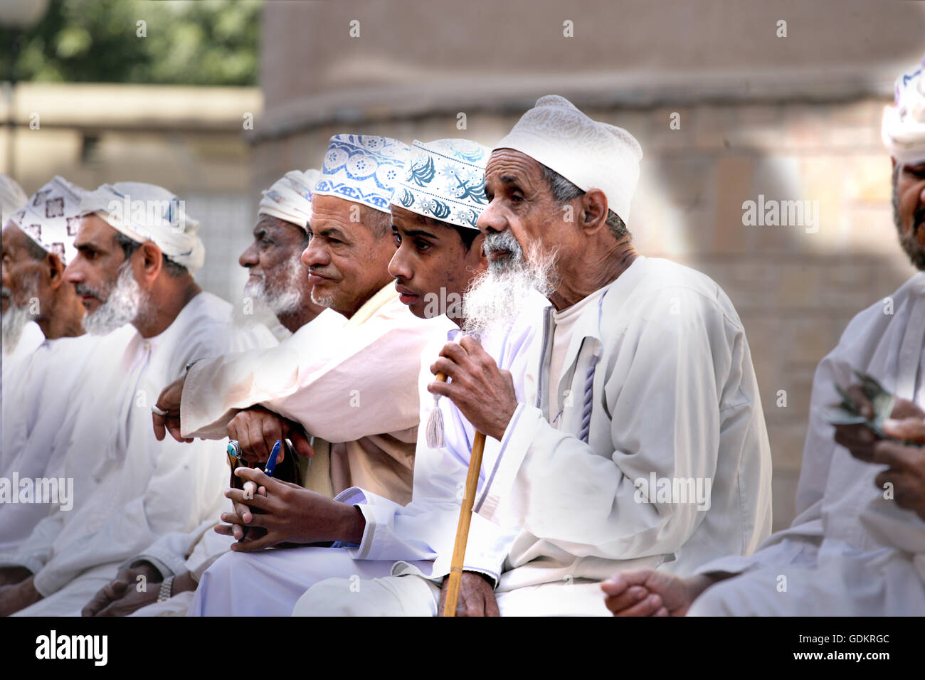 Men sitting on a wall, Oman Stock Photo - Alamy