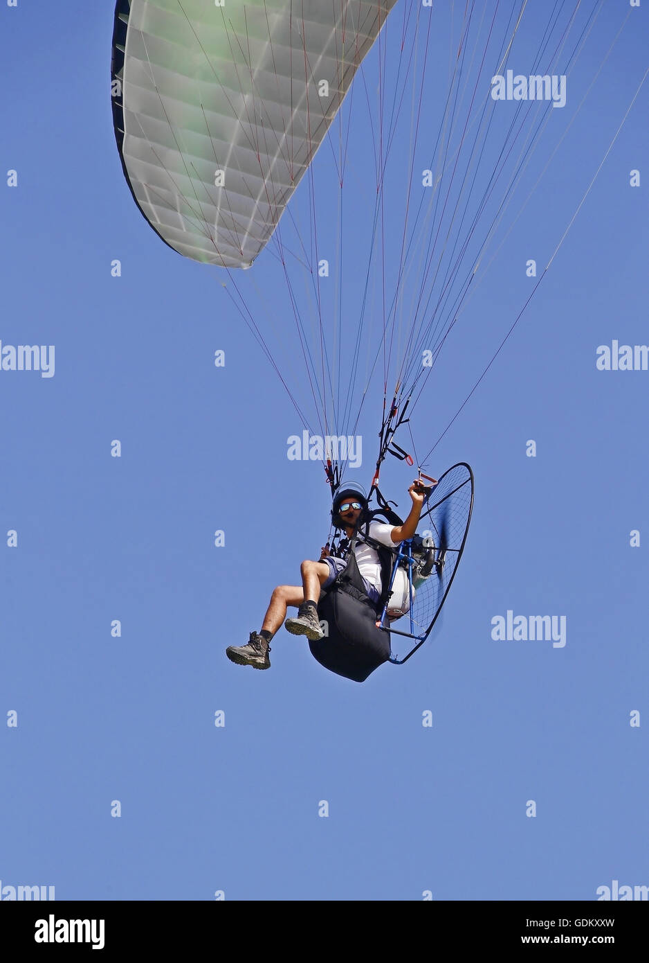 man flying on a parachute blue sky background Stock Photo - Alamy