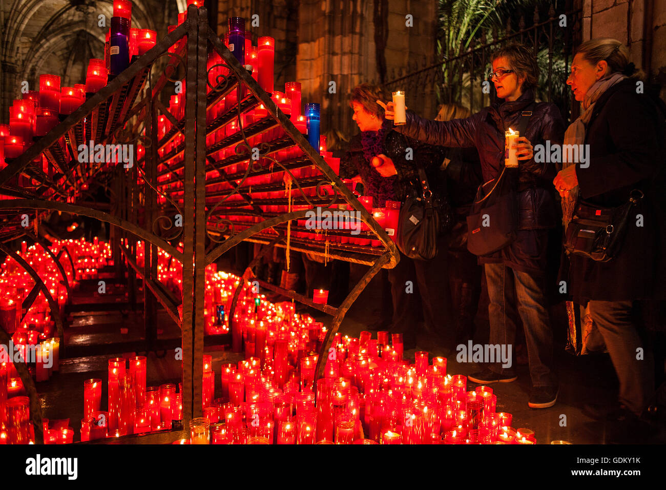 Barcelona's cathedral, Gothi. People praying and Lighted candles ...