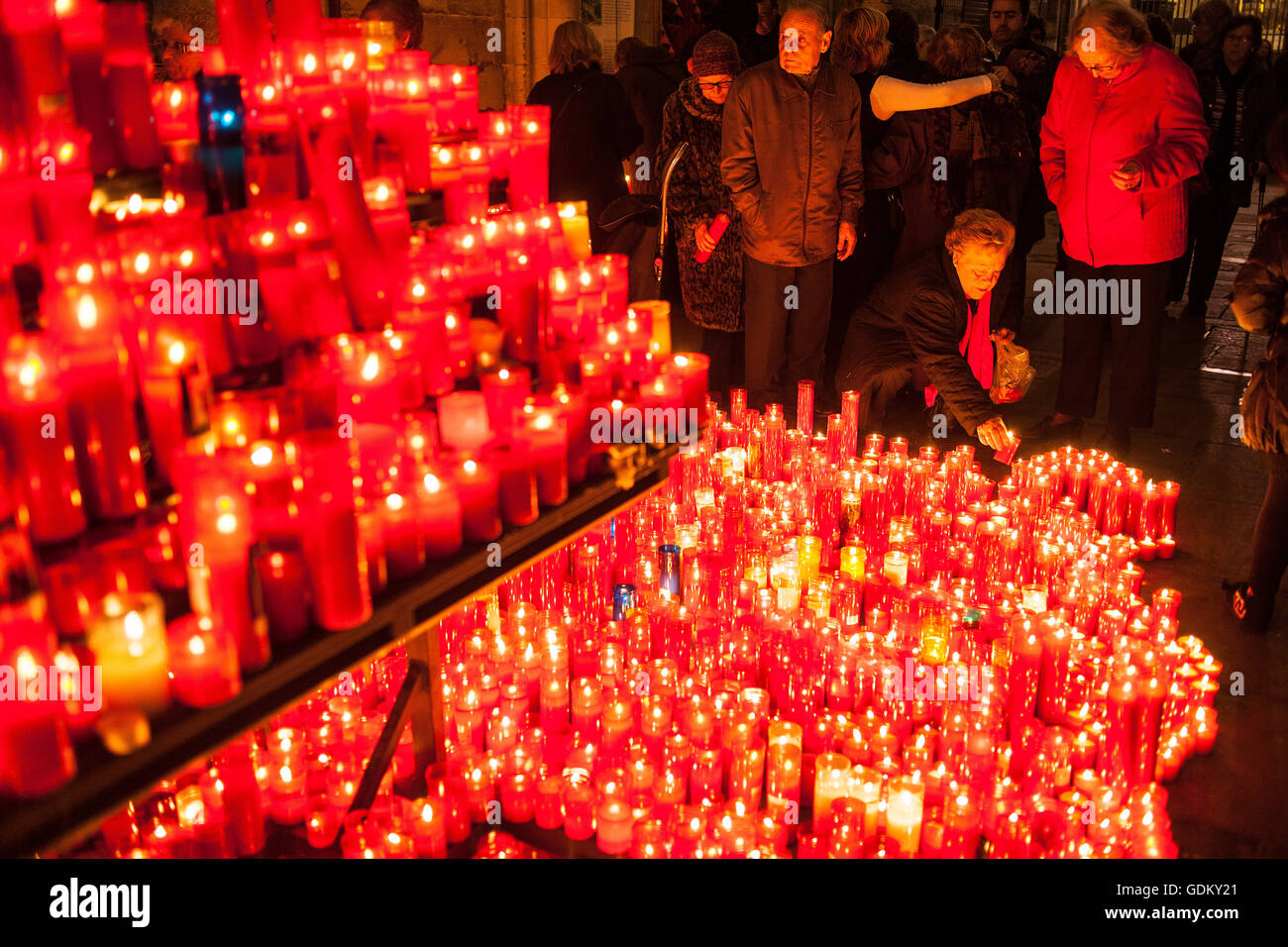 Barcelona's cathedral, Gothi. People praying and Lighted candles ...