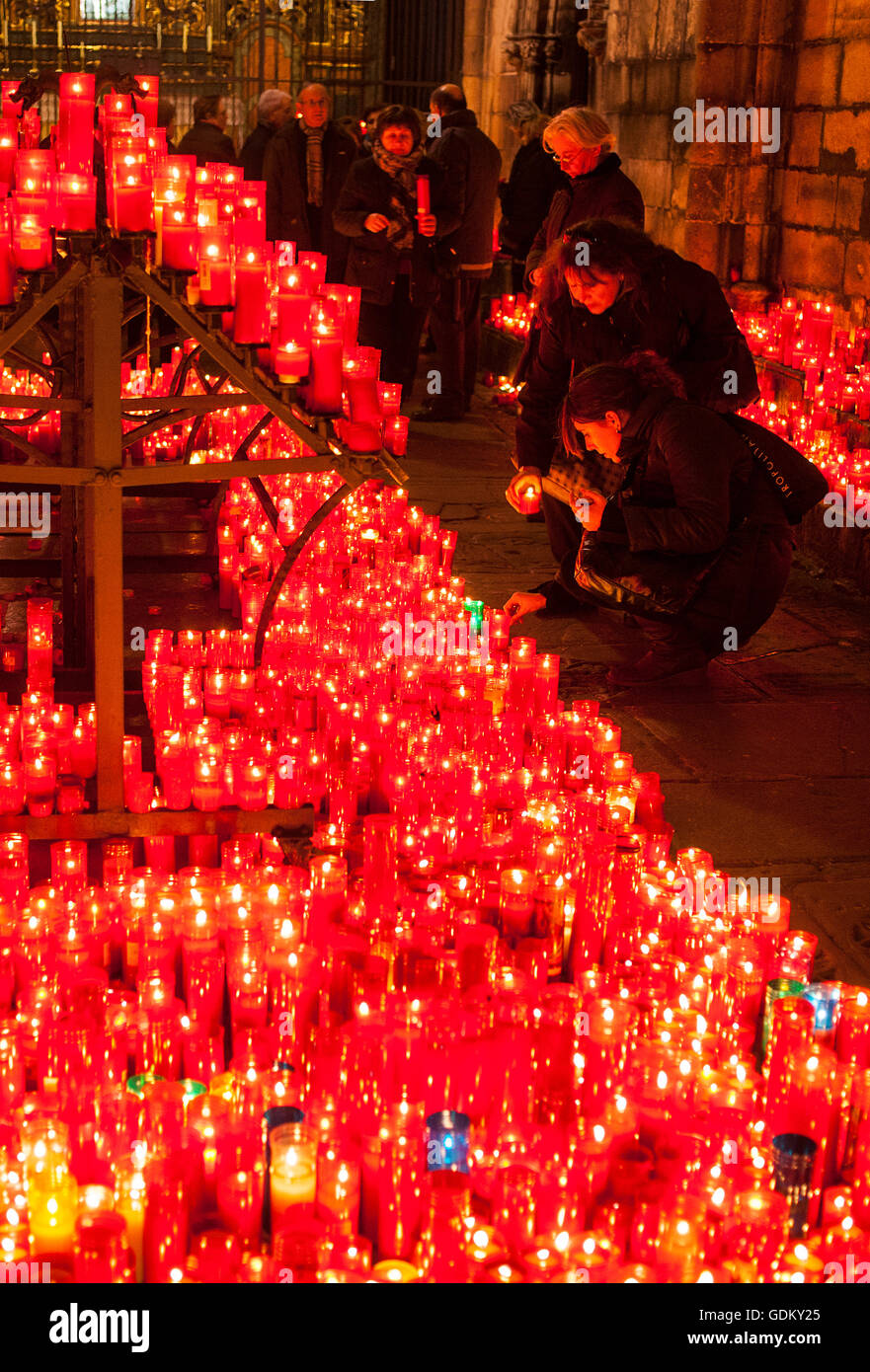 Barcelona's cathedral, Gothi. People praying and Lighted candles ...