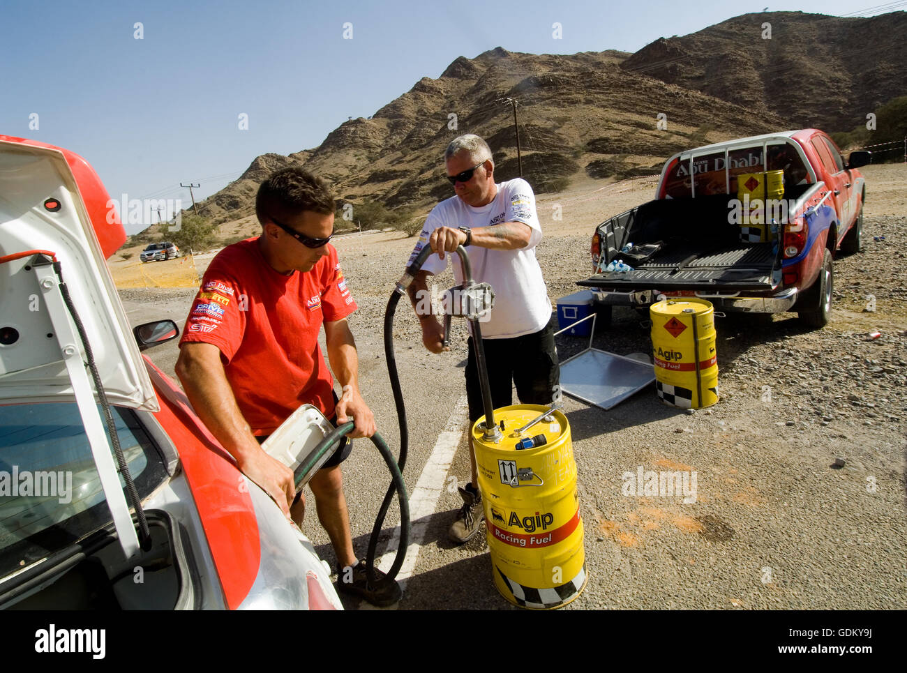 Team support fills a car at a rest station at the Oman Rally, Muscat ...