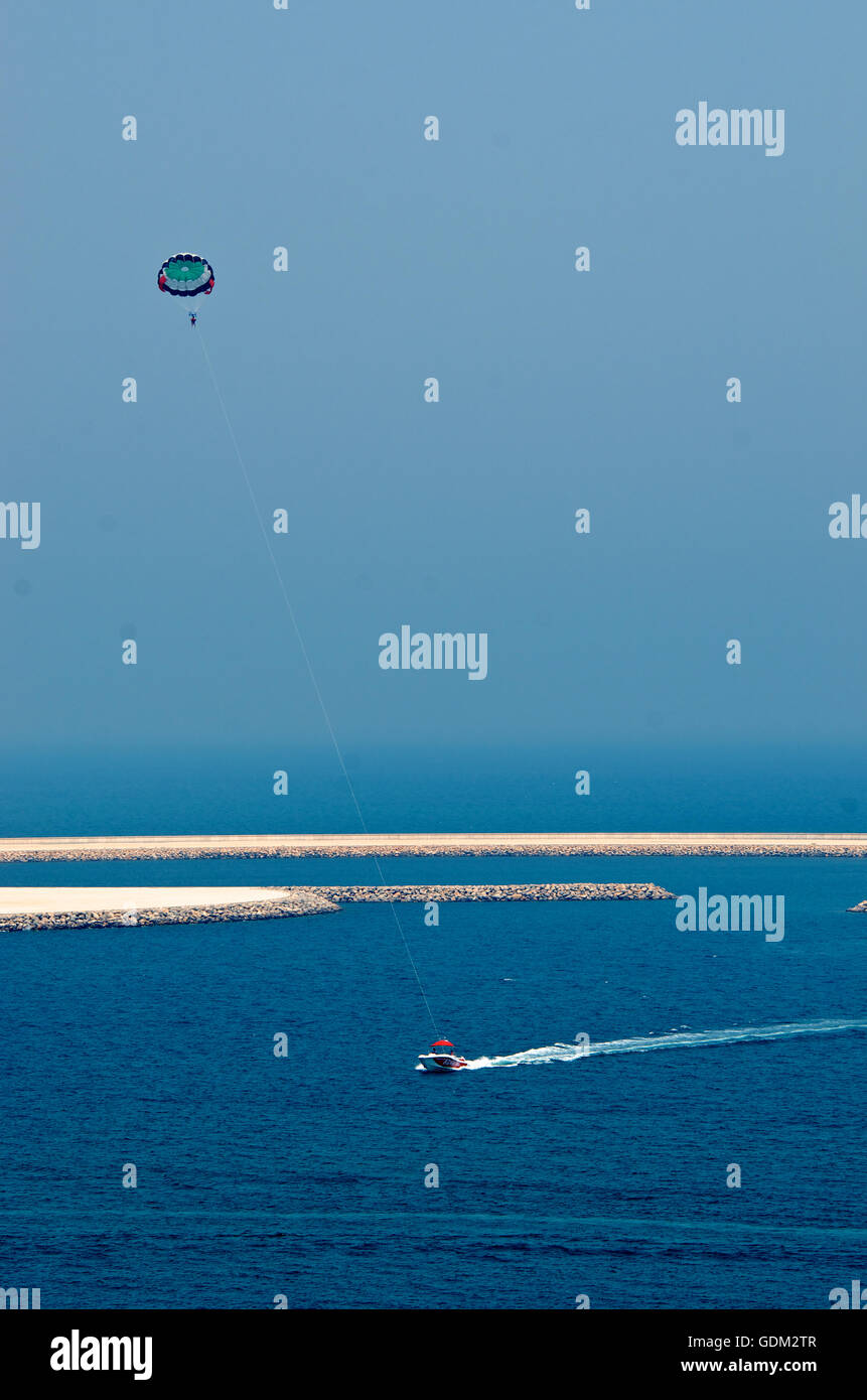 A parasail pulled high above a motorboat Stock Photo - Alamy