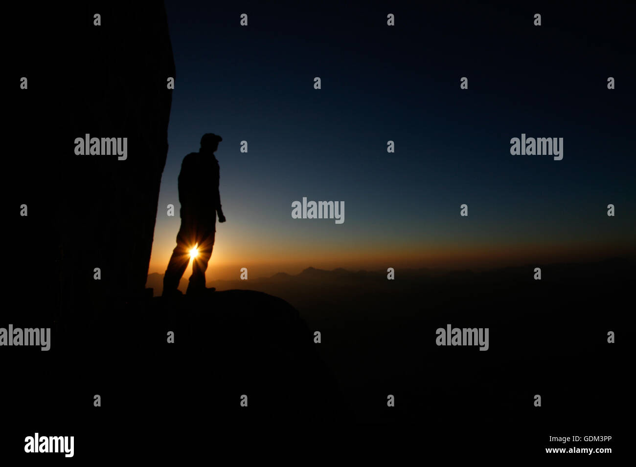 Silhouette of standing man with sun rising in background Stock Photo ...