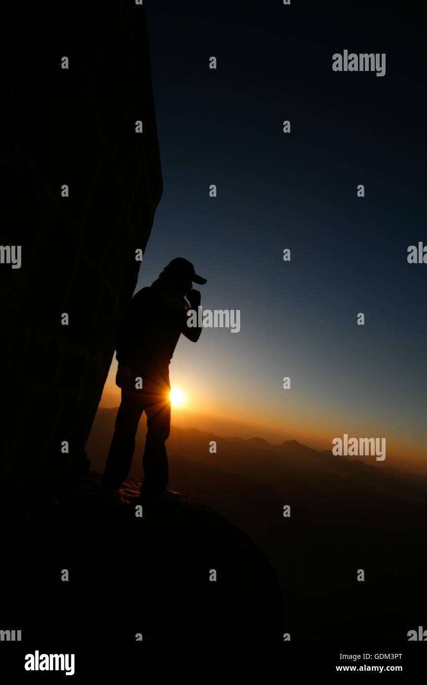 Silhouette of standing man with sun rising in background Stock Photo ...