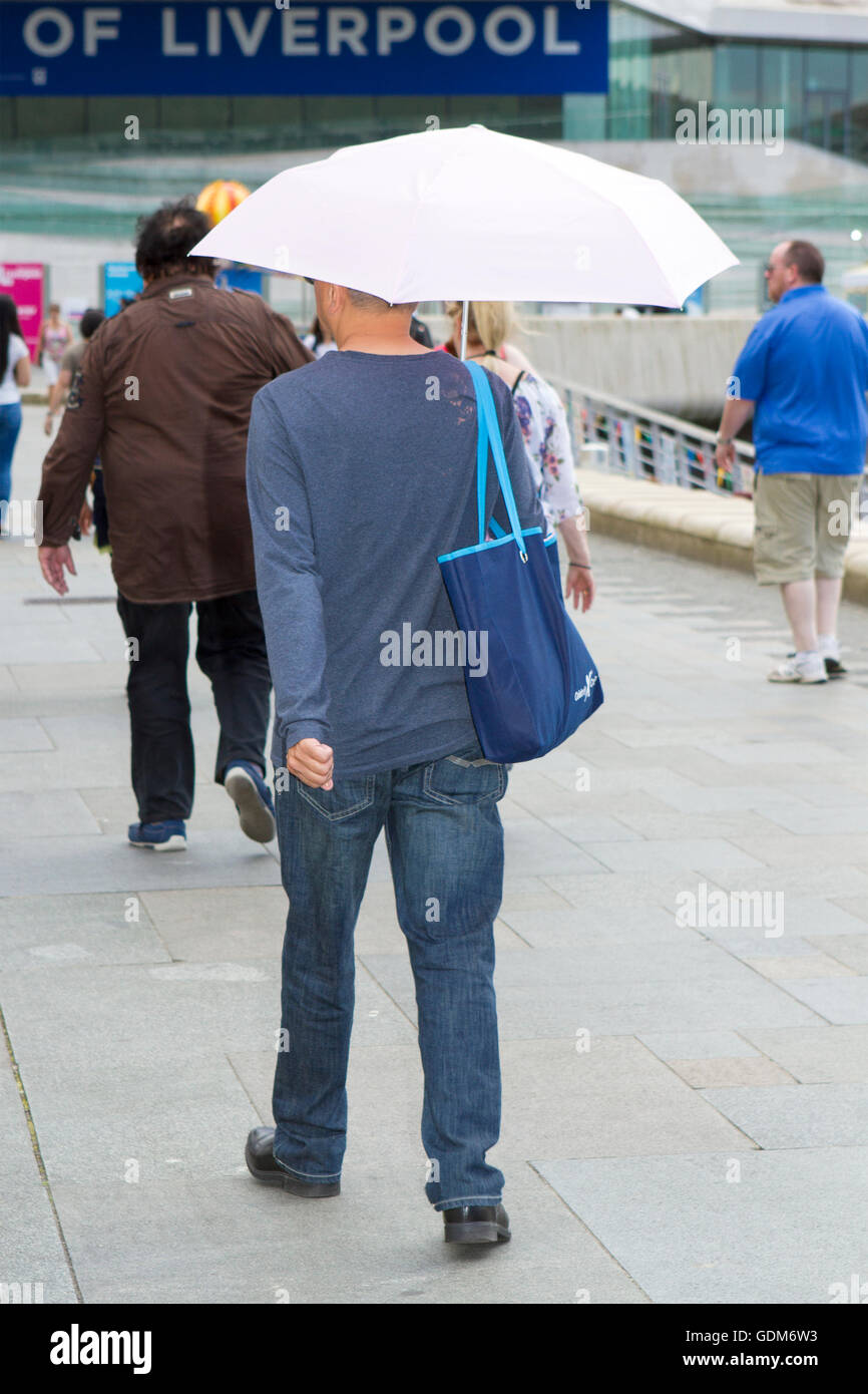 People shading under umbrellas from the hot summer sun Stock Photo - Alamy