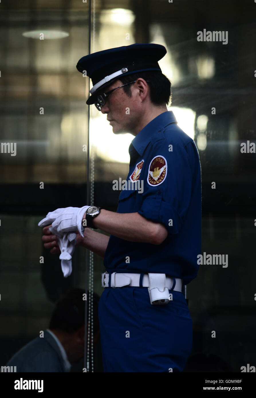 Tokyo, Japan. 16th July, 2016. A train station security guard put on ...