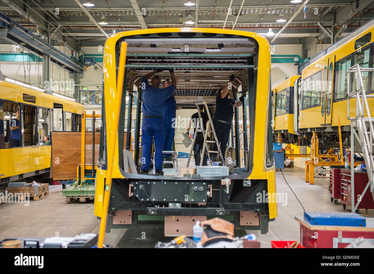 A worker assembles parts of a train at the production site of train ...
