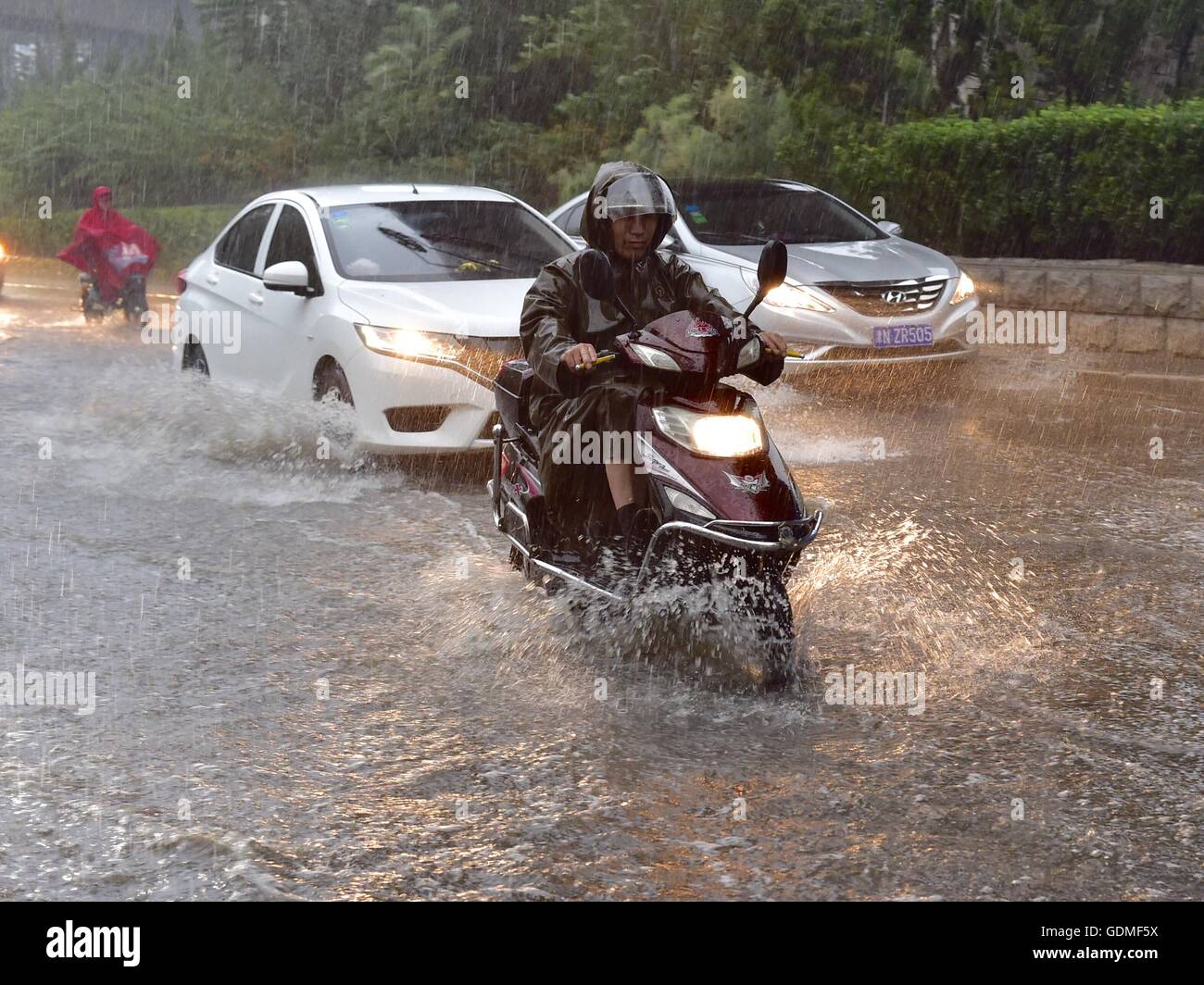 Tianjin, China. 20th July, 2016. A resident ride a motorcycle on a ...