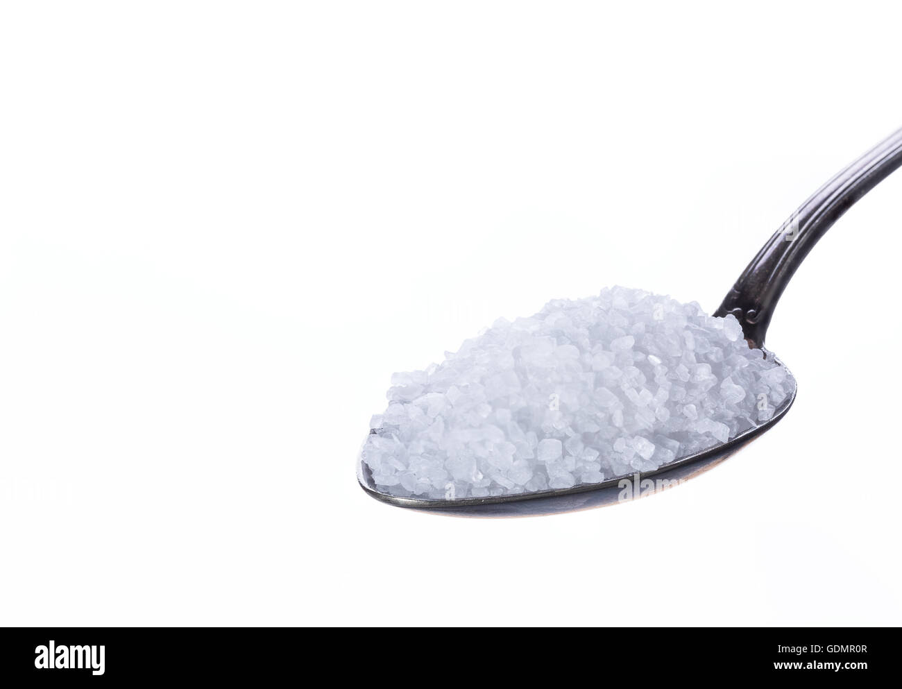 Sea salt on old spoon isolated on white background, closeup with copy ...