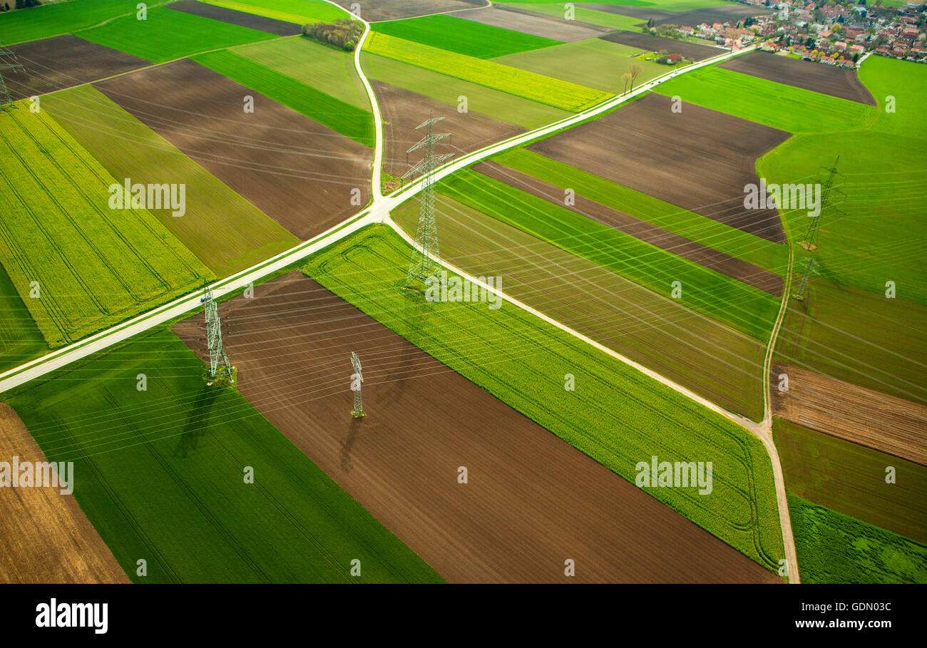 High-voltage transmission lines over farm fields in spring, aerial view ...