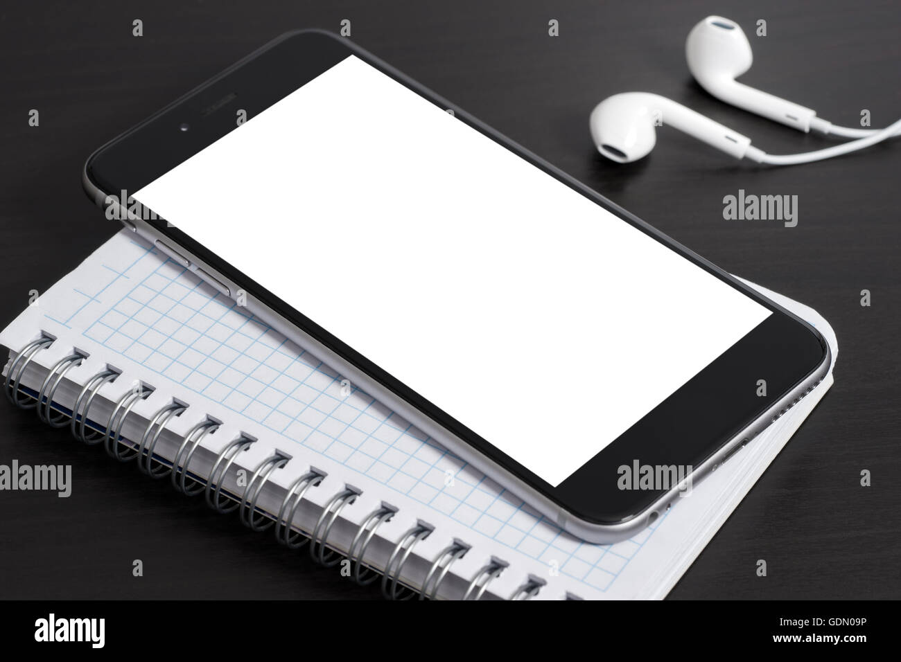 Smartphone and notepad on dark table, headphones Stock Photo - Alamy