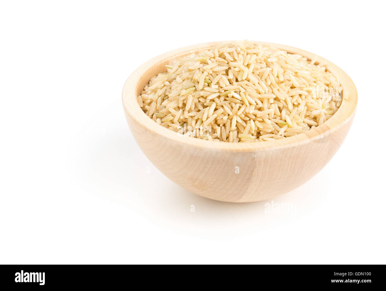 Natural brown uncooked rice in wooden bowl over white background Stock ...
