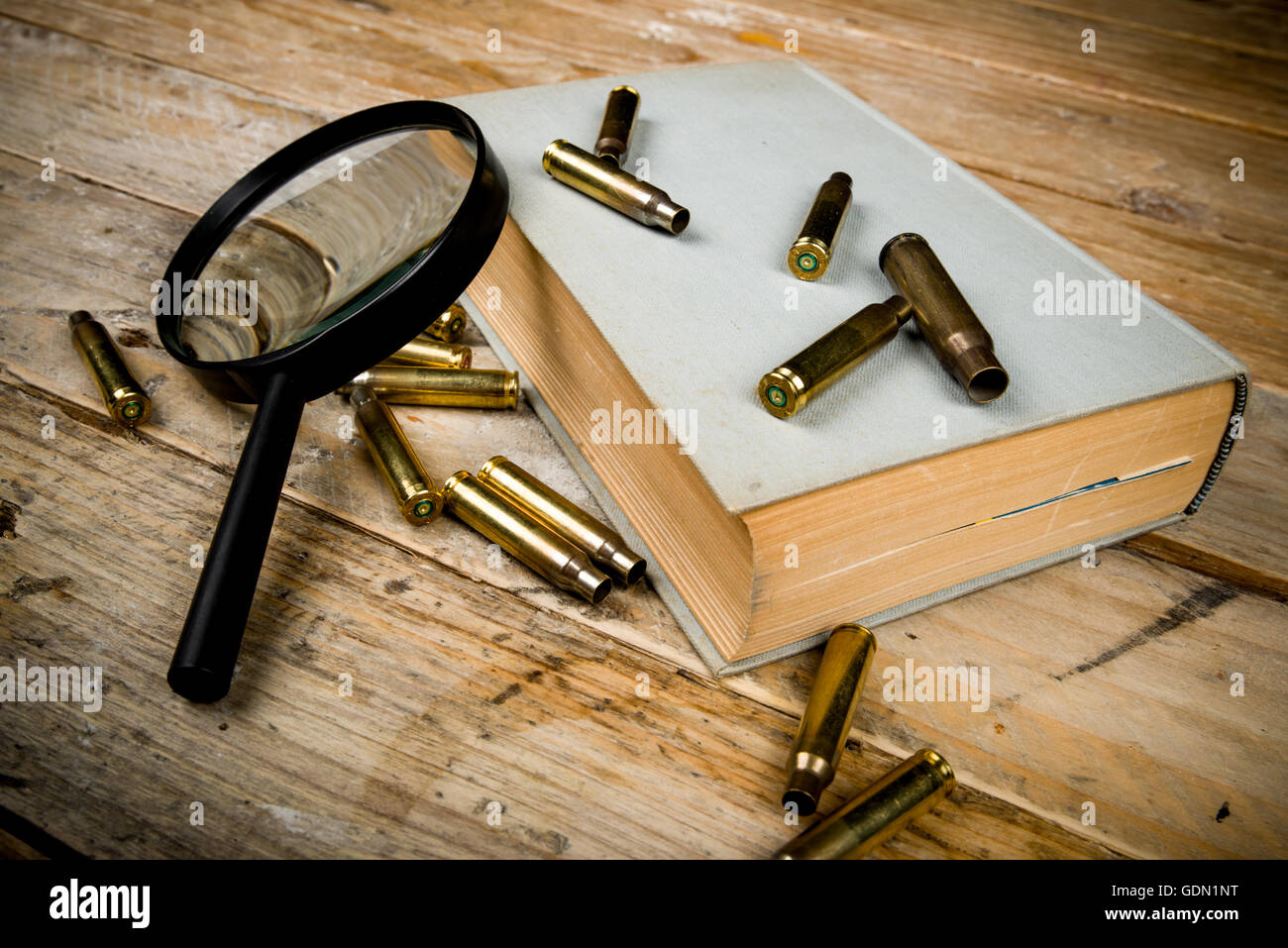 Detective novel concept with book, bullets and magnyfying glass Stock ...