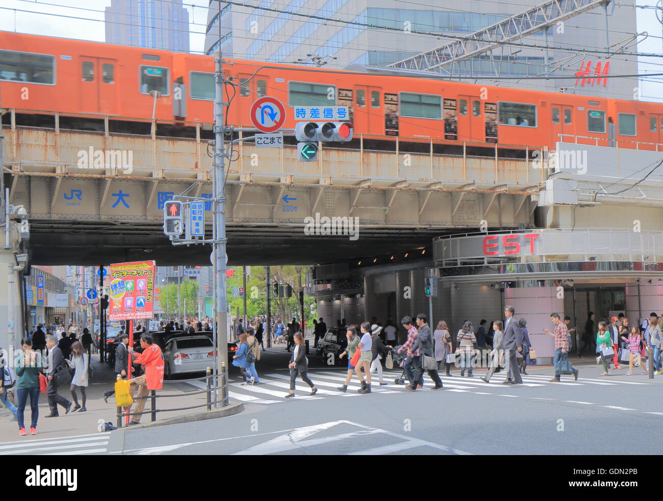 People walk under train rail crossing bridge in Osaka Japan Stock Photo ...