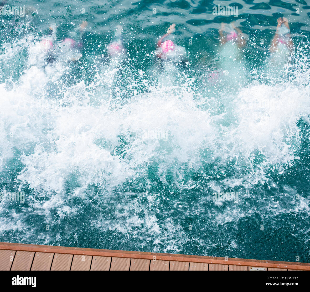 Female triathletes diving into sea at start of triathlon race Stock ...