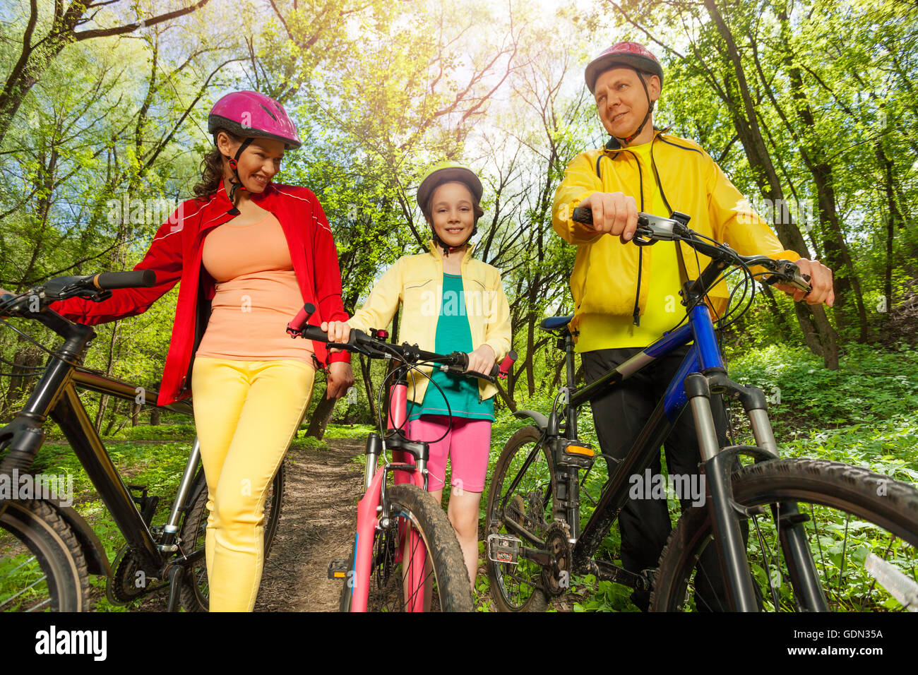 Active family with mountain bikes walking in park Stock Photo - Alamy