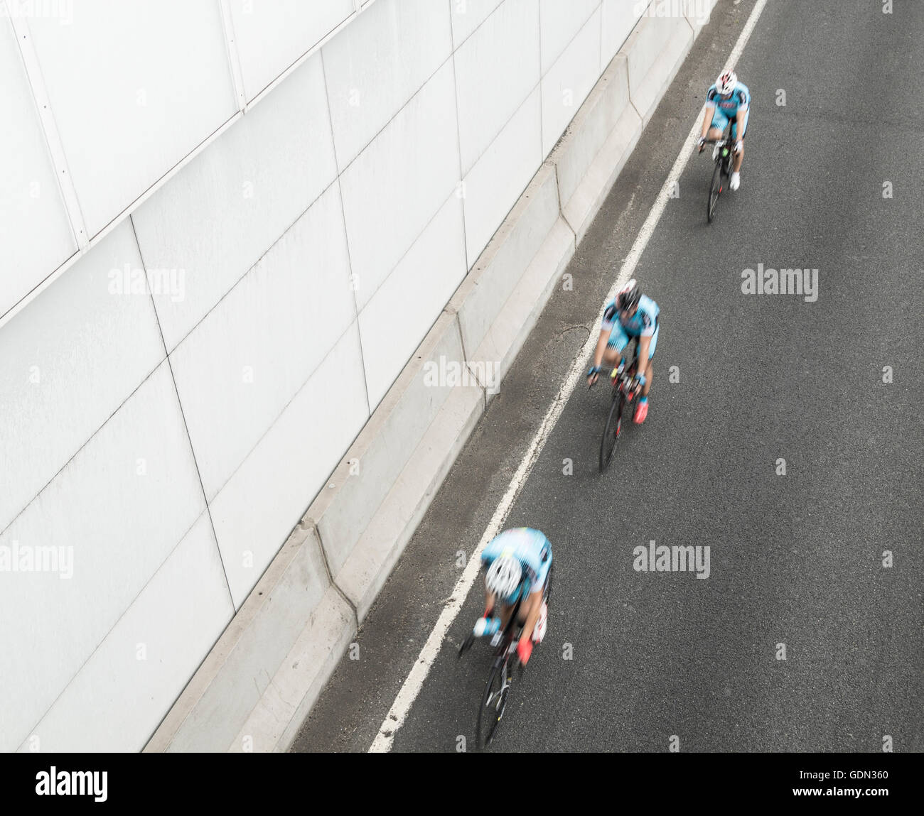 Overhead view of three cyclists about to enter city centre tunnel Stock ...
