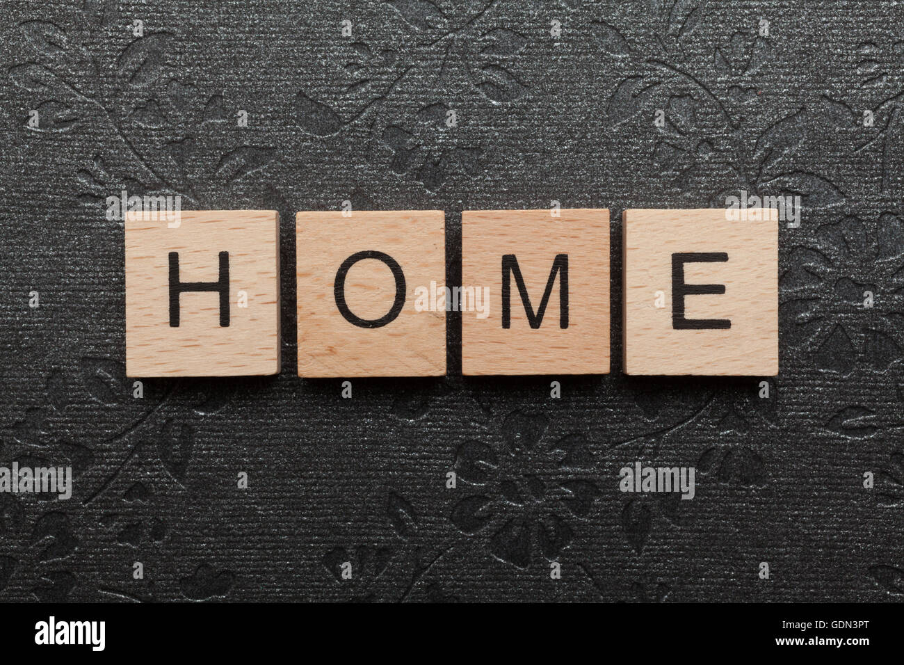 Wooden letters spelling HOME on black background Stock Photo - Alamy