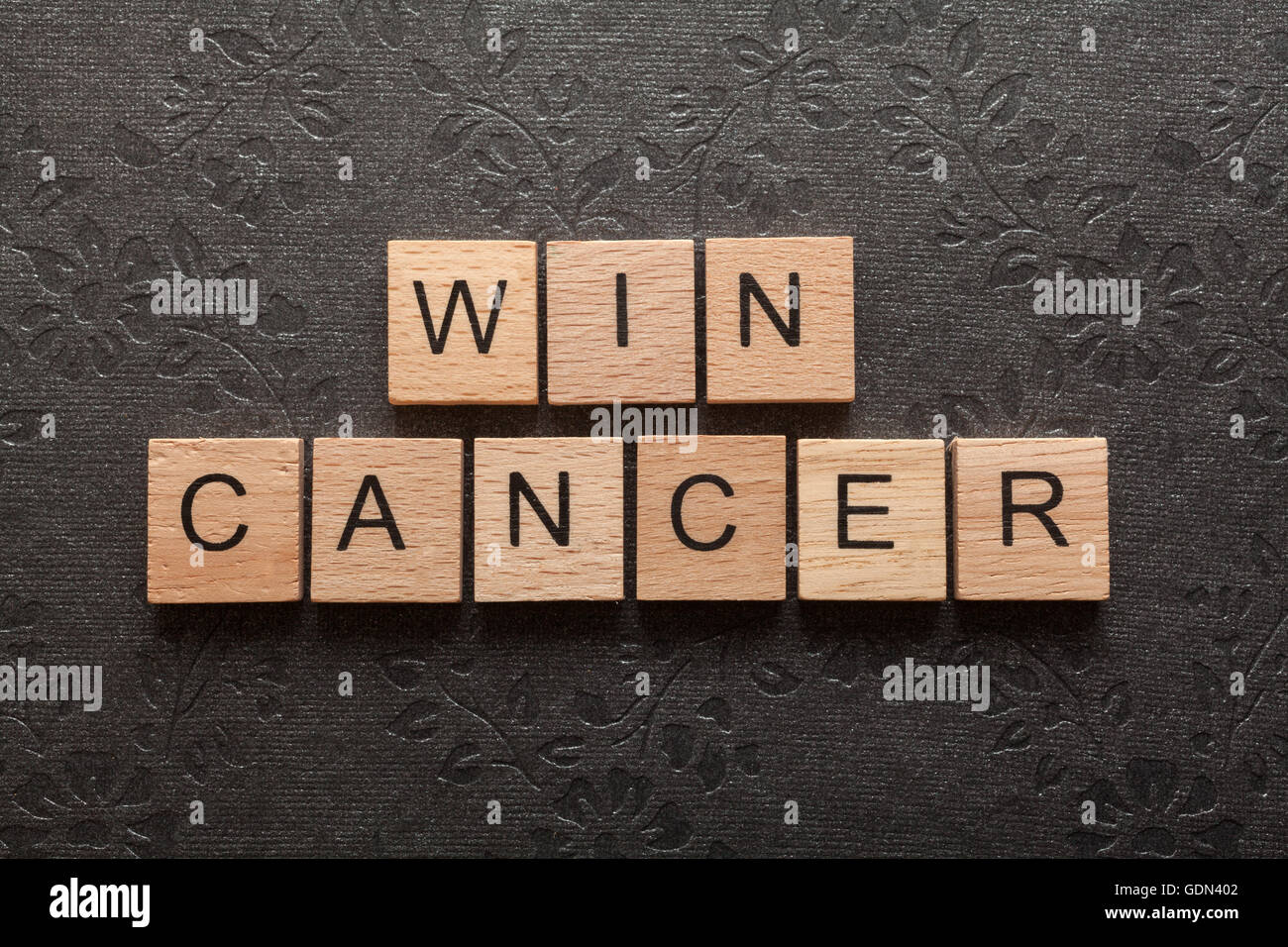 Wooden letters spelling WIN CANCER on black background Stock Photo - Alamy
