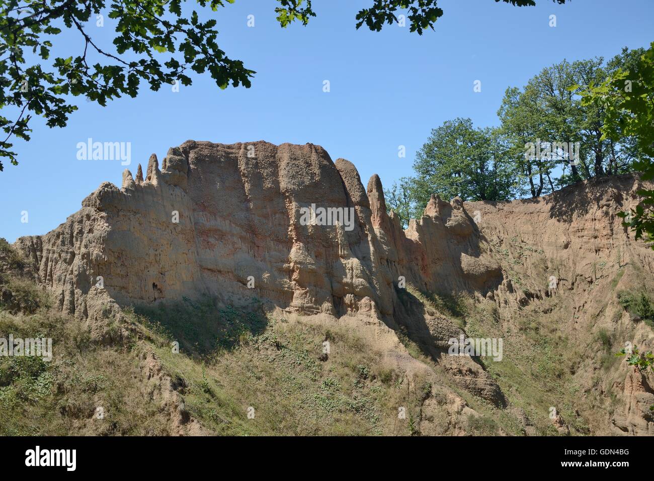 Sand pyramids and cliff face of heavily eroded, weathered soft ...