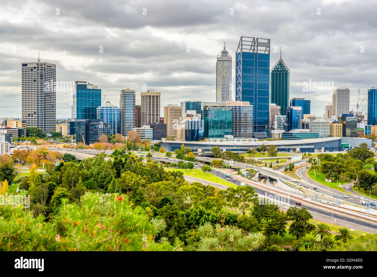 Perth city with modern glass buildings towering above the freeway below ...
