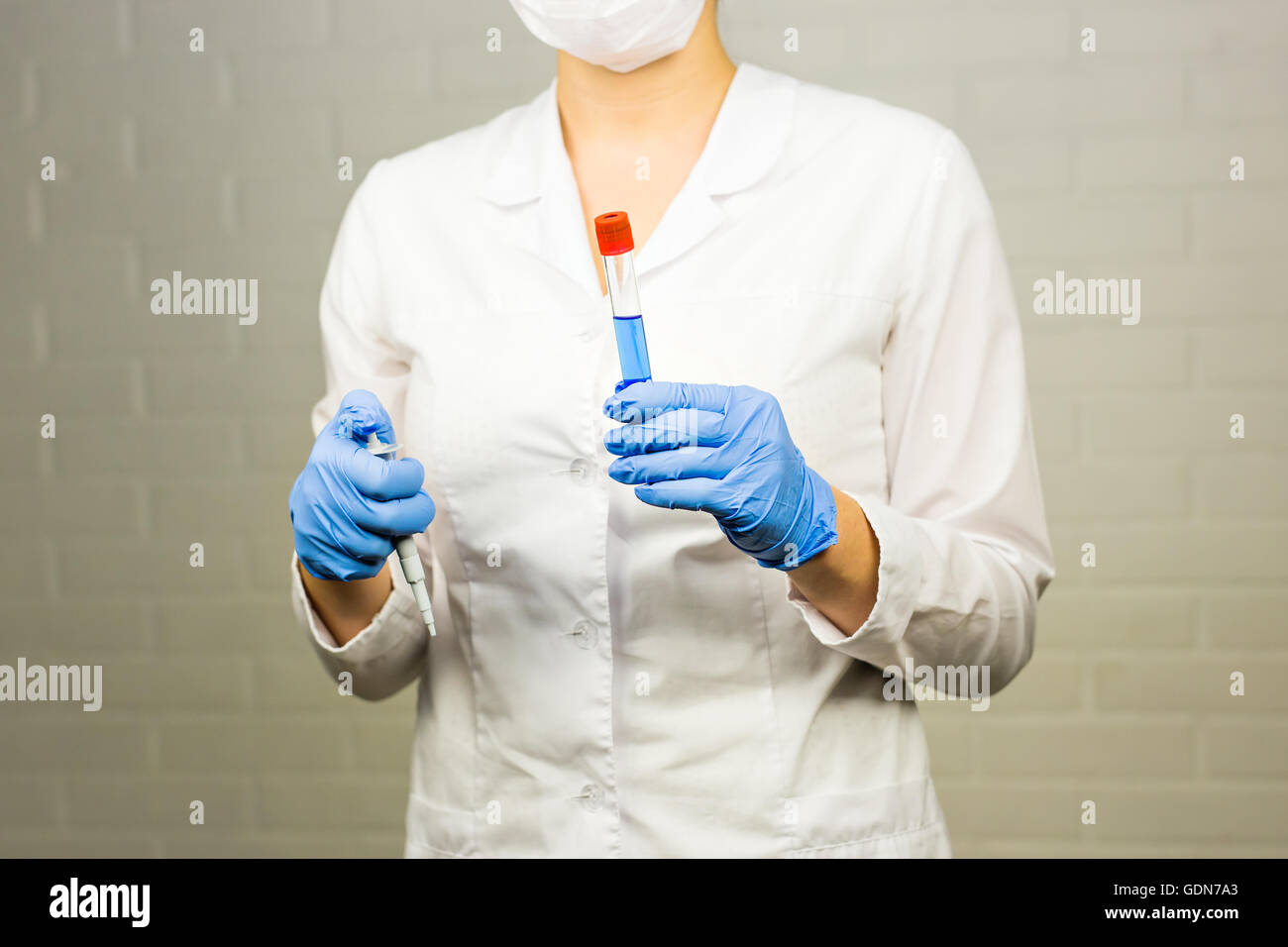 female medical or scientific researcher with a test tube of clear ...