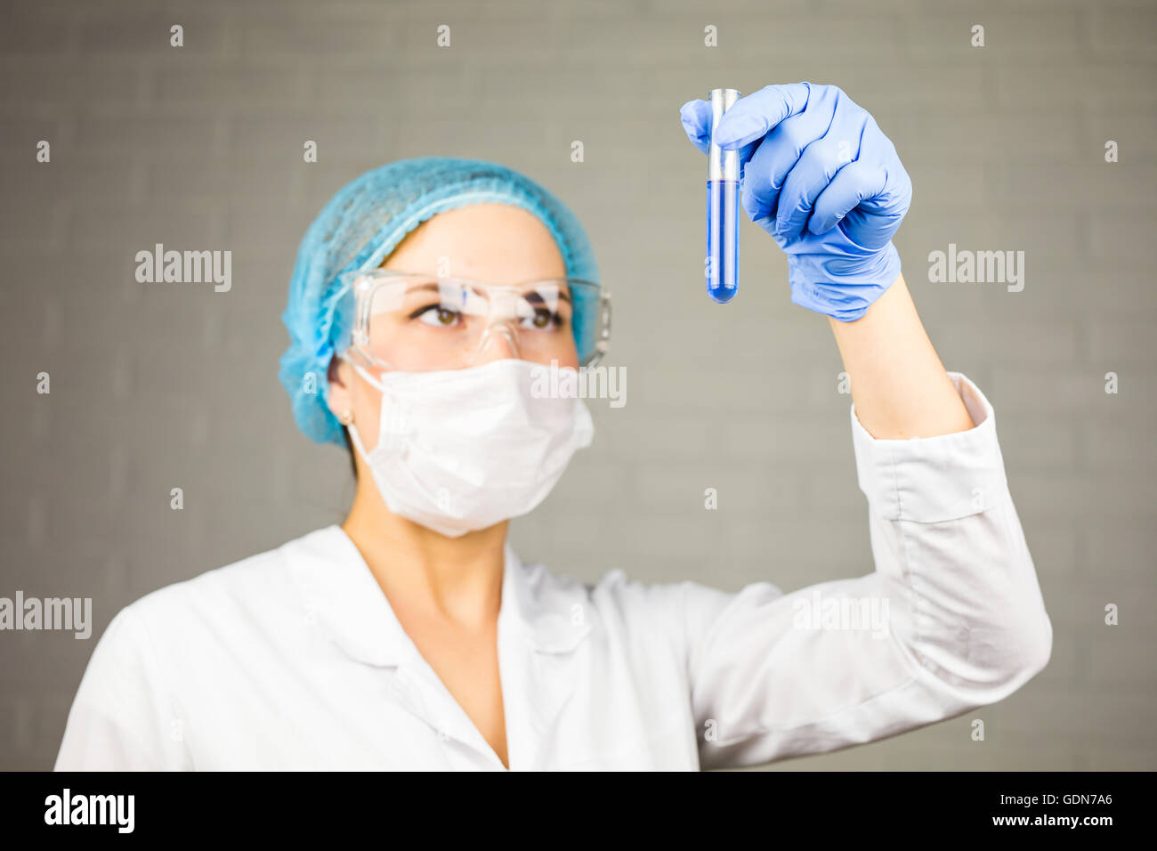 female medical or scientific researcher with a test tube of clear ...