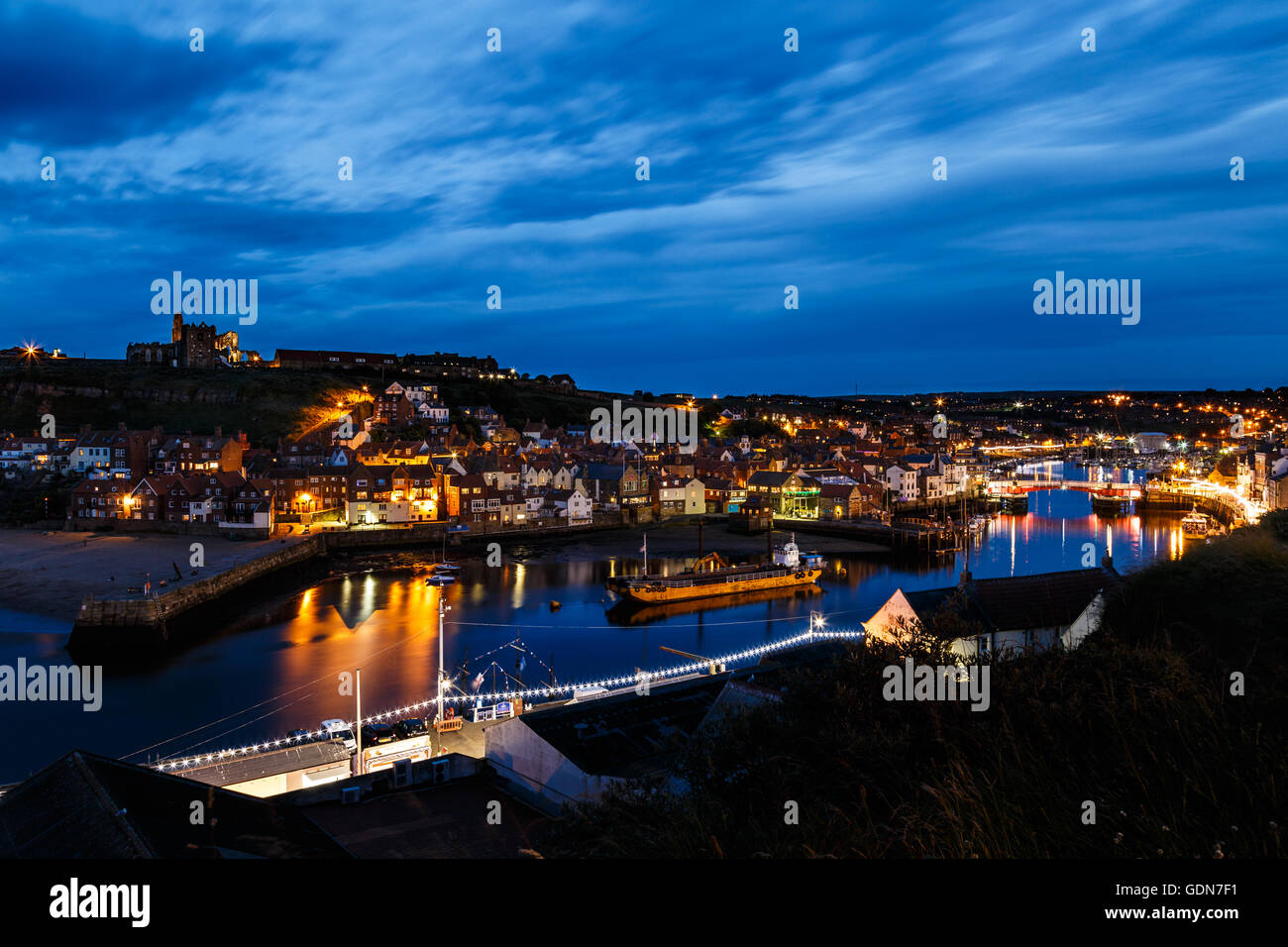 Whitby Abbey, with harbour in foreground, at night. In Whitby, North ...