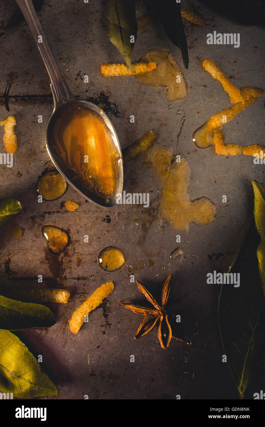 Orange jam in a spoon on a iron table with star anise and orange leafs ...