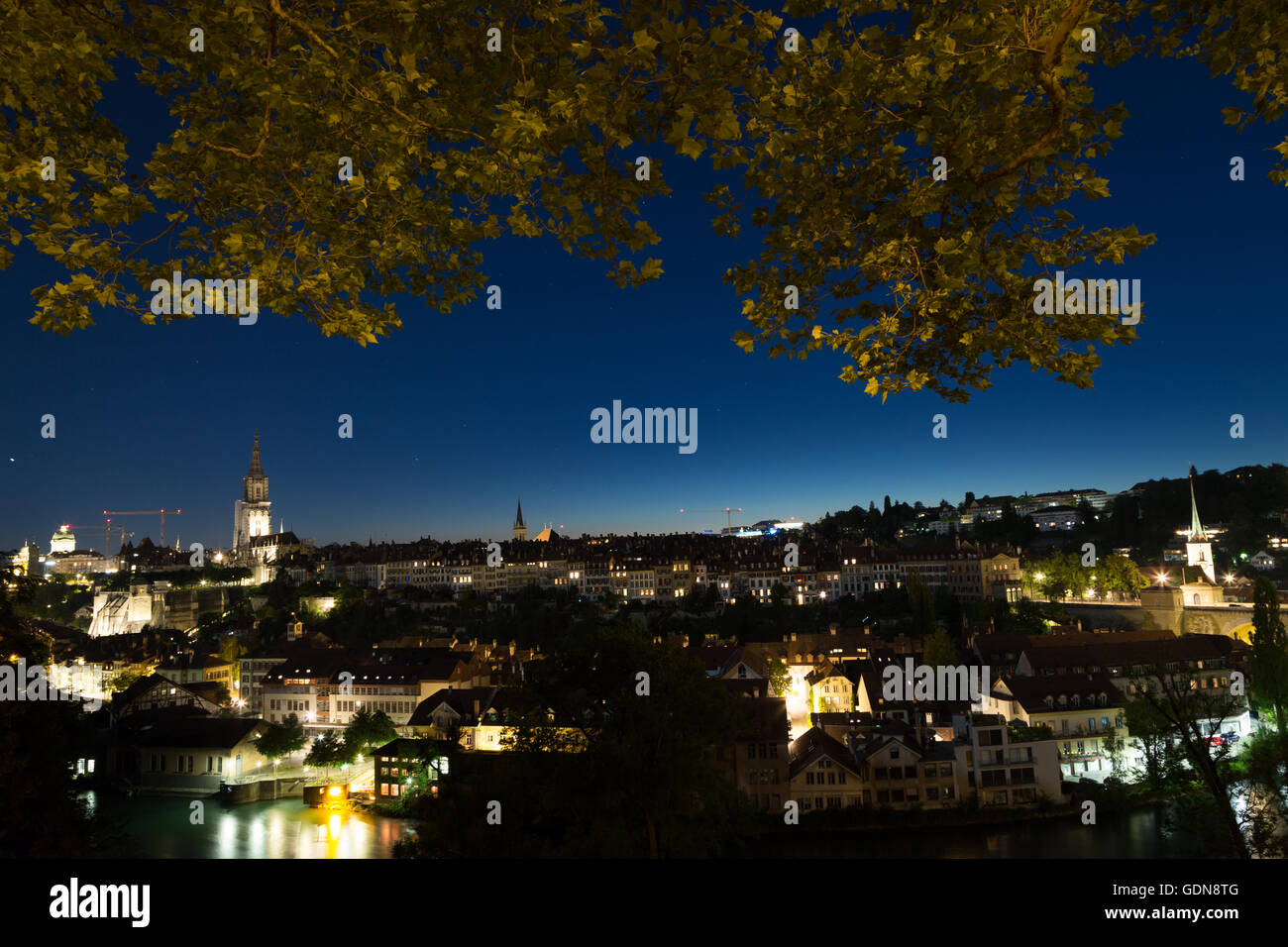 A photograph of the old city of Bern at night, with the River Aare ...