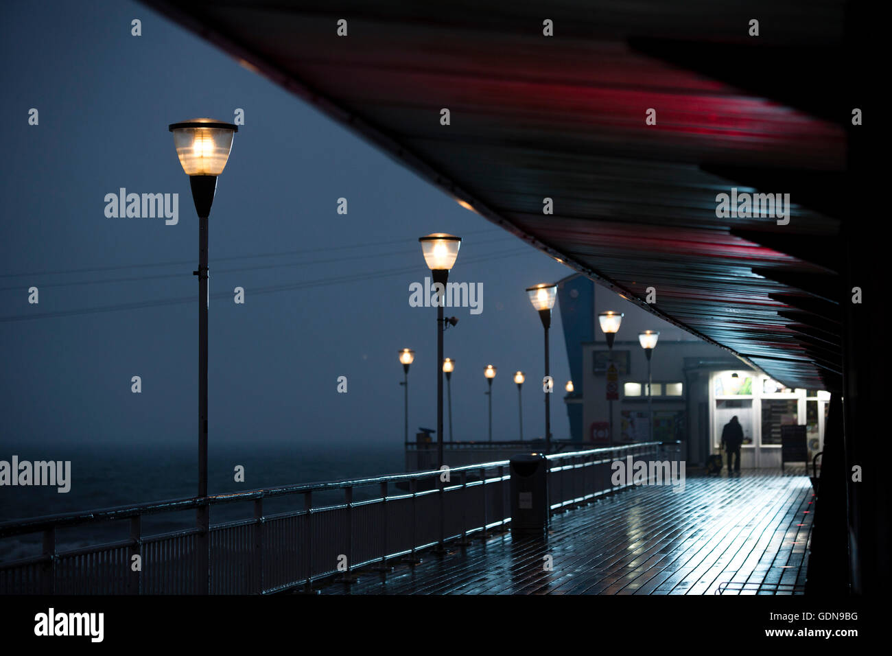 Night time on Bournemouth pier with coloured lights reflecting on the ...